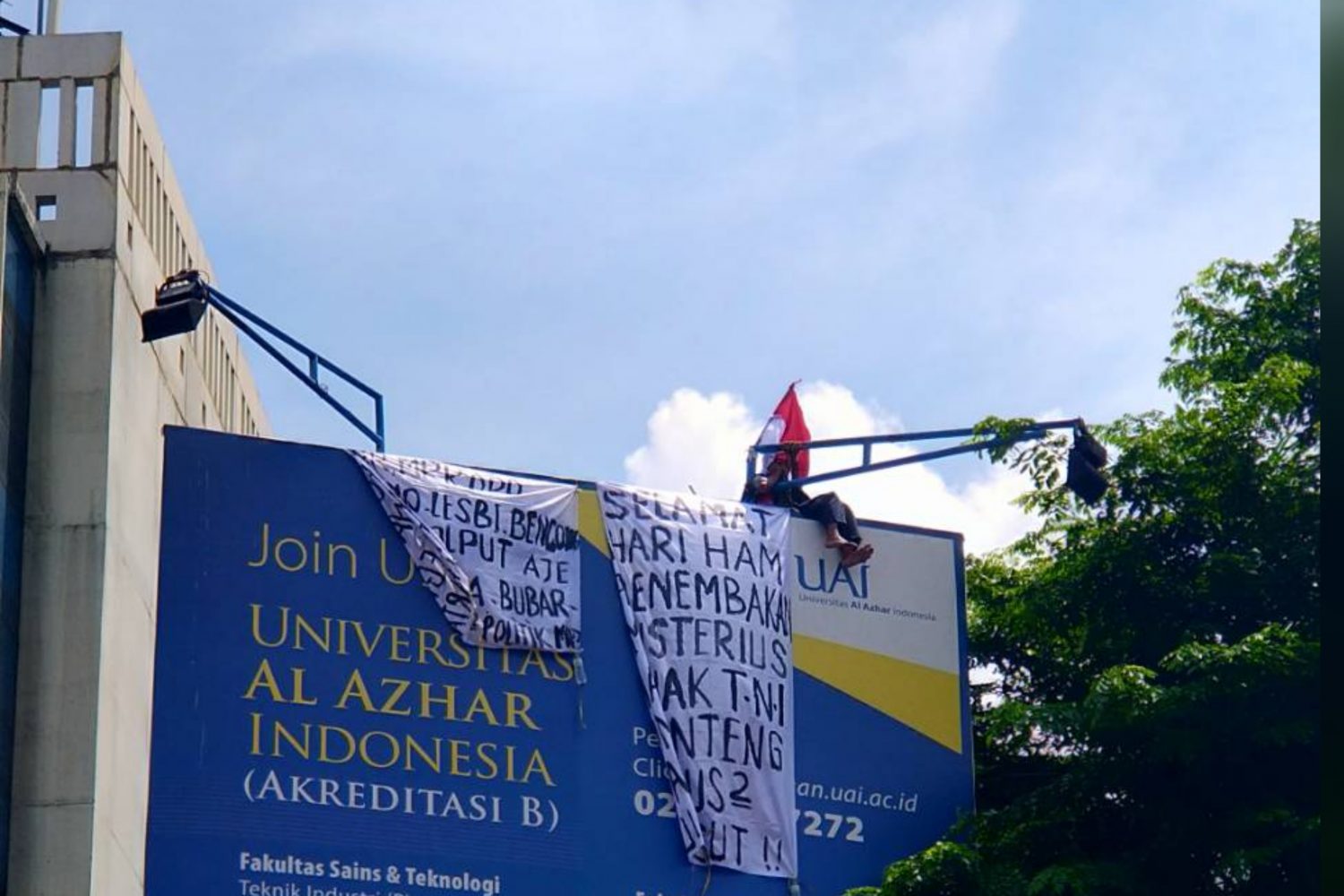 Pria Misterius Panjat Baliho Universitas Al Azhar Indonesia - deCODE